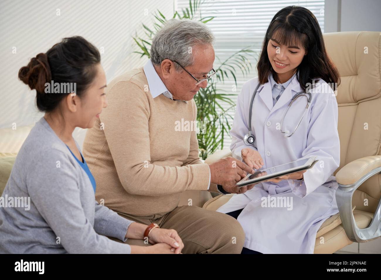 Smiling doctor showing medical test results to senior patients Stock ...