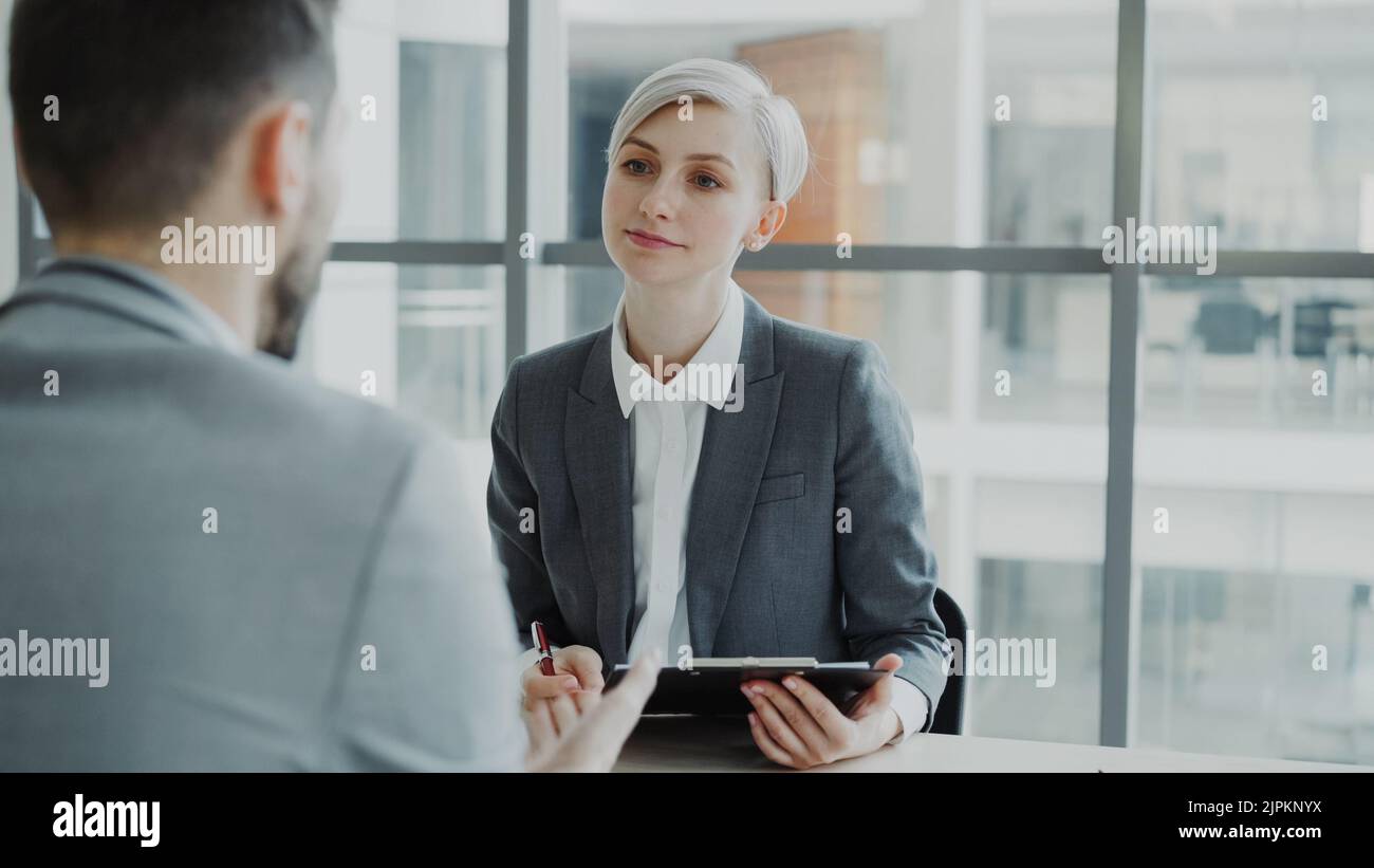 HR businesswoman having job interview with young man in suit and ...