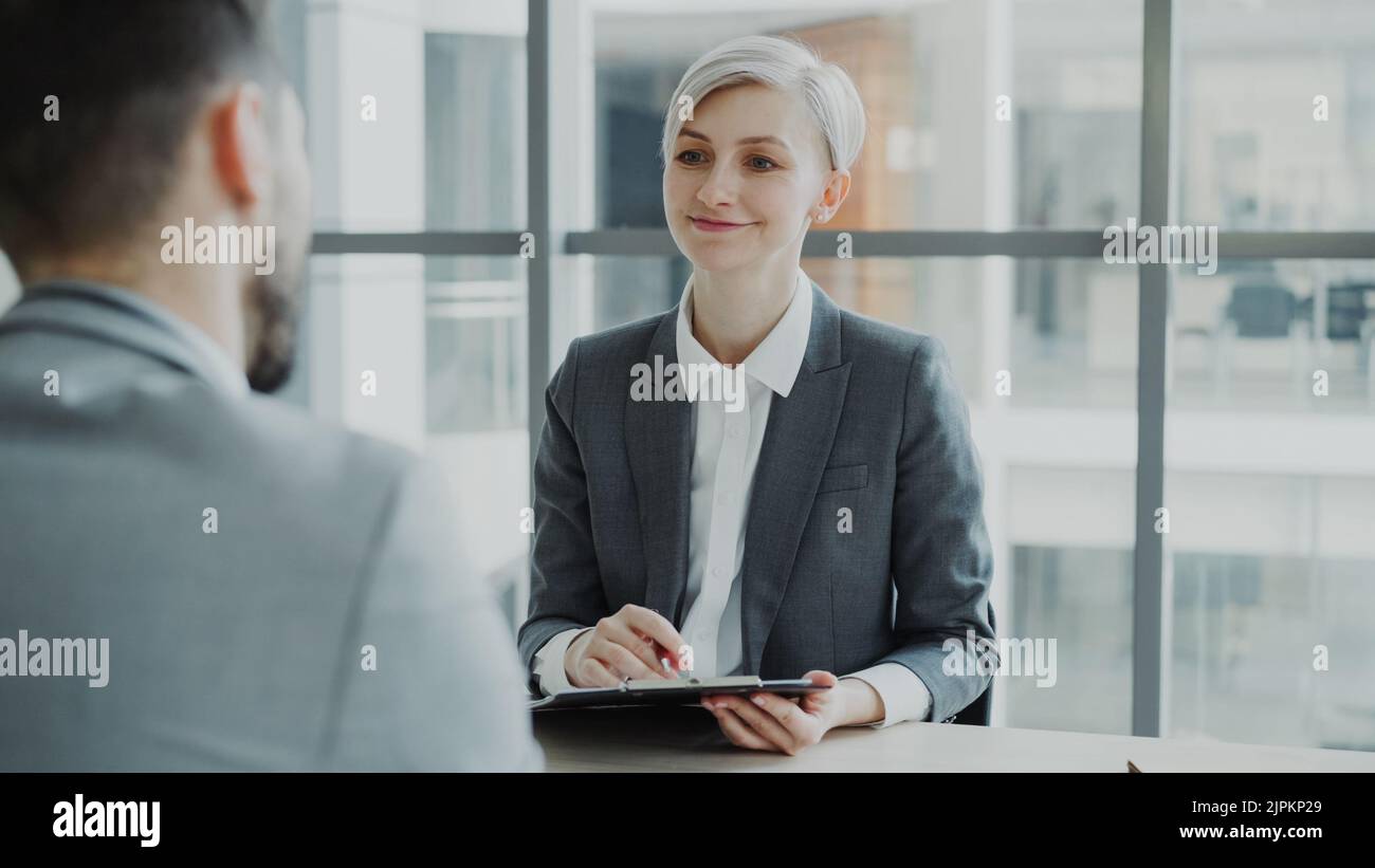 HR businesswoman having job interview with young man in suit and ...