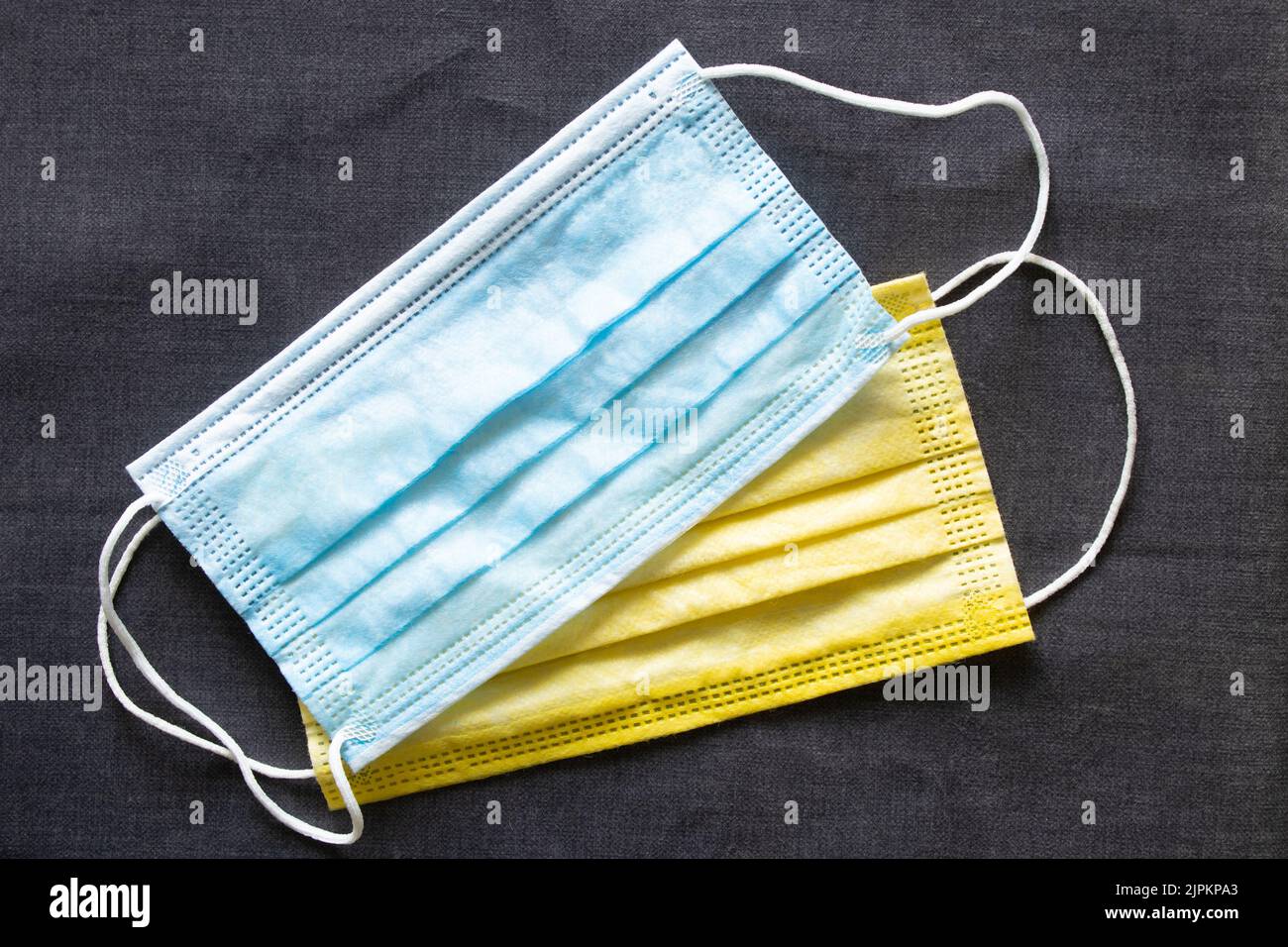 Medical masks, yellow and blue, like the flag of Ukraine, lie on the ...