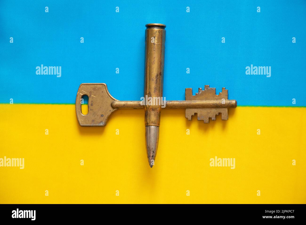 Yellow-blue national flag of Ukraine and a key with a bullet, war in ...