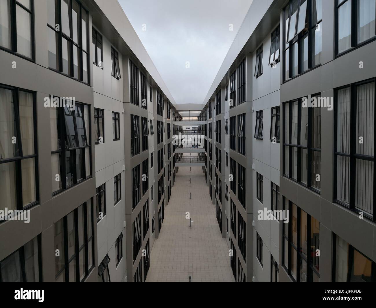 A Outside corridor between gray modern buildings Stock Photo - Alamy
