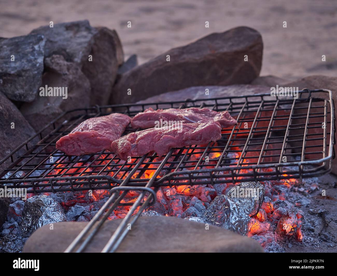 Game meat being roasted on a barbecue on open fire Stock Photo - Alamy