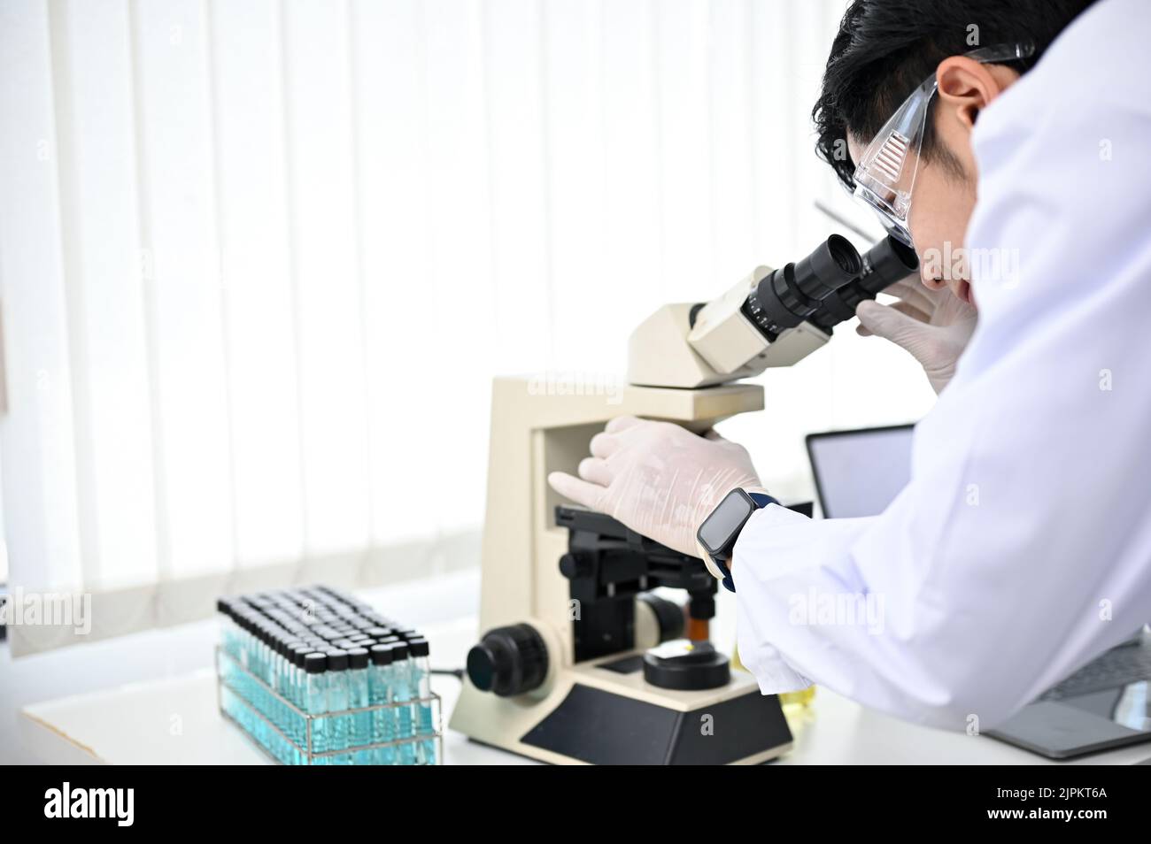 Talented and handsome young Asian male scientist or chemist looking ...