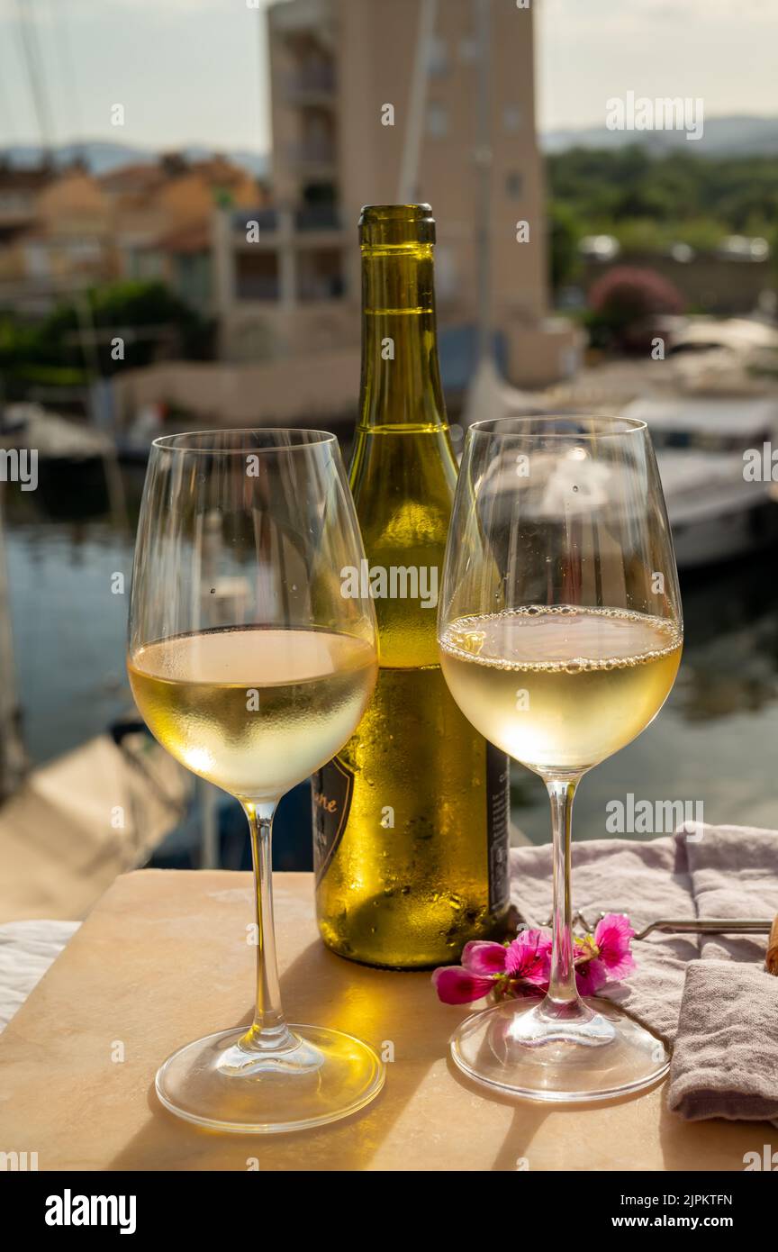 Drinking of cold white wine with view on yacht harbour of Port Grimaud ...