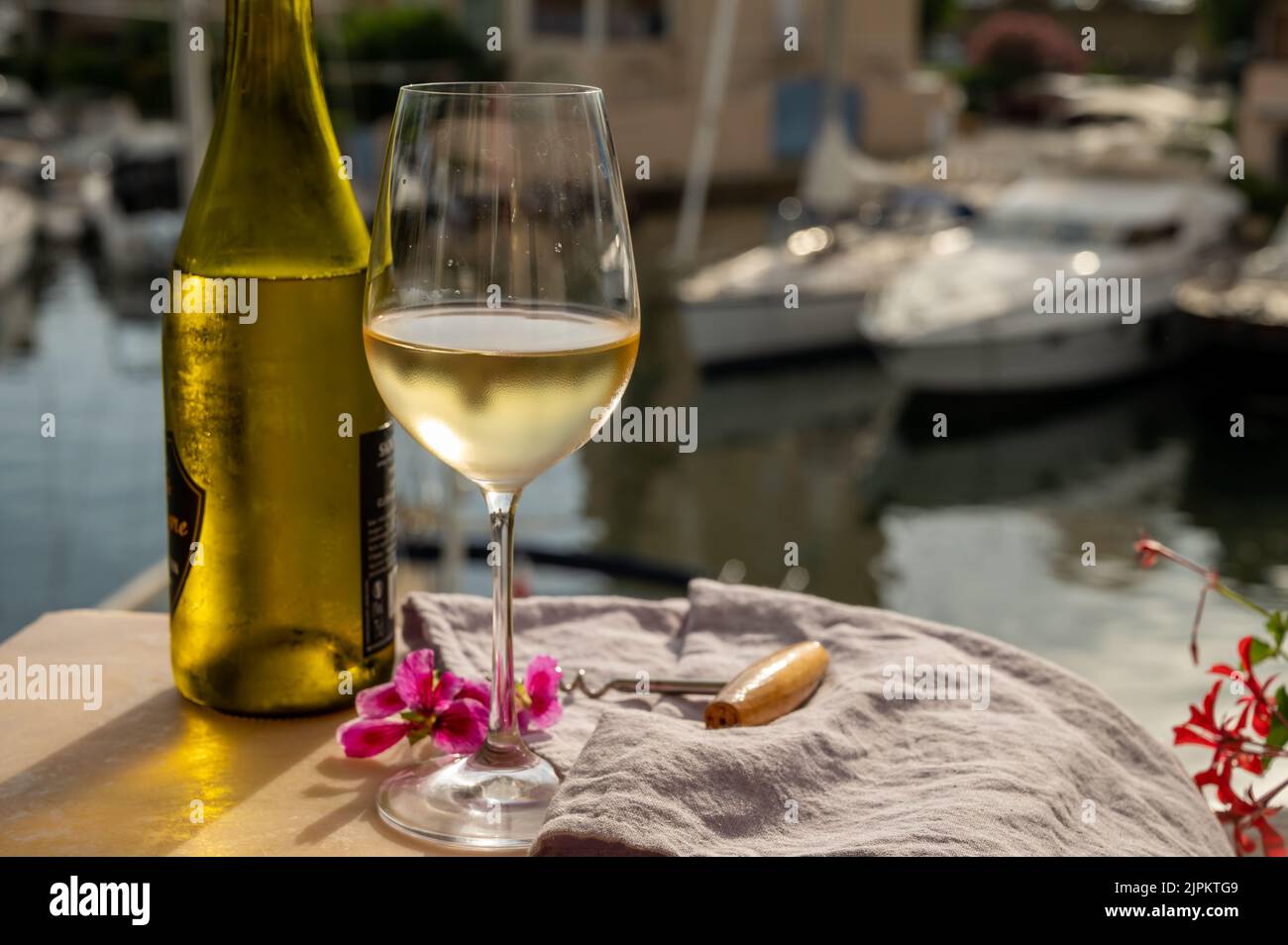 Drinking of cold white wine with view on yacht harbour of Port Grimaud ...