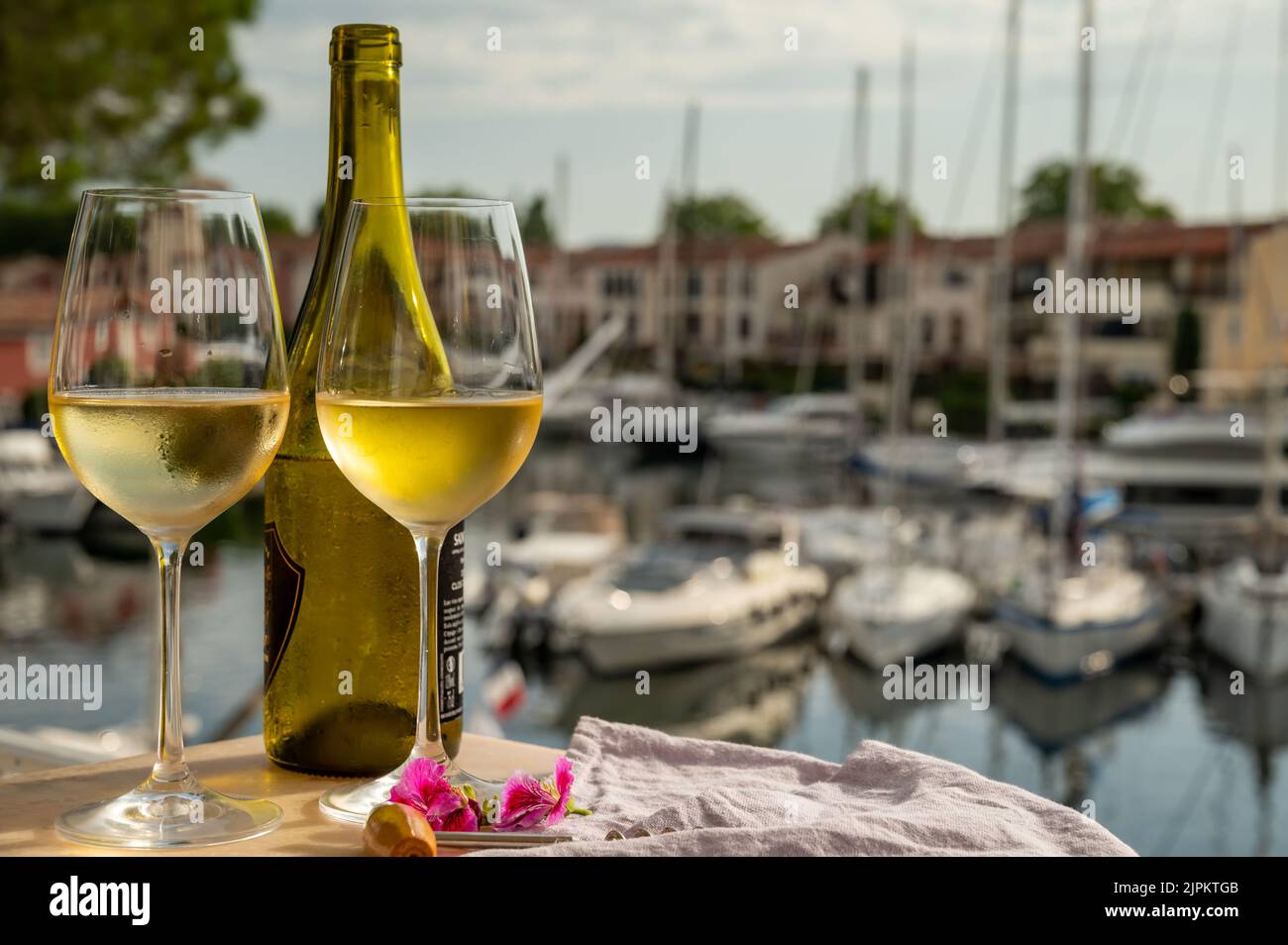 Drinking of cold white wine with view on yacht harbour of Port Grimaud ...