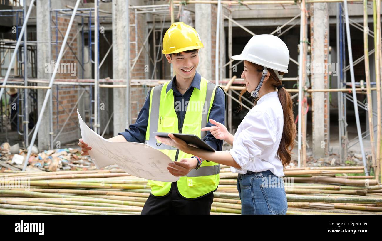 Two talented young Asian male and female civil engineer discussing and ...