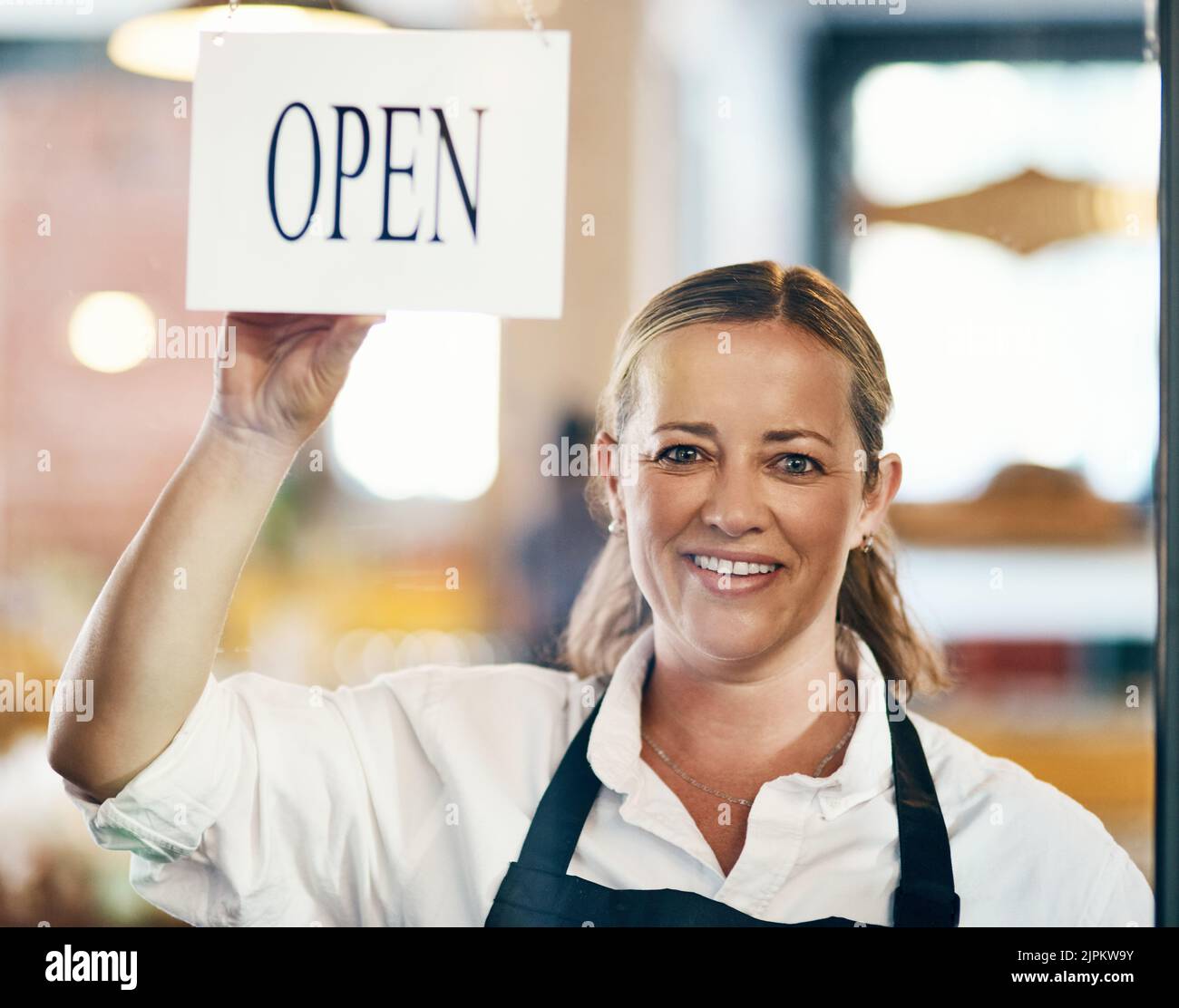Cafe owner opening her new startup, store or welcoming customers to a ...
