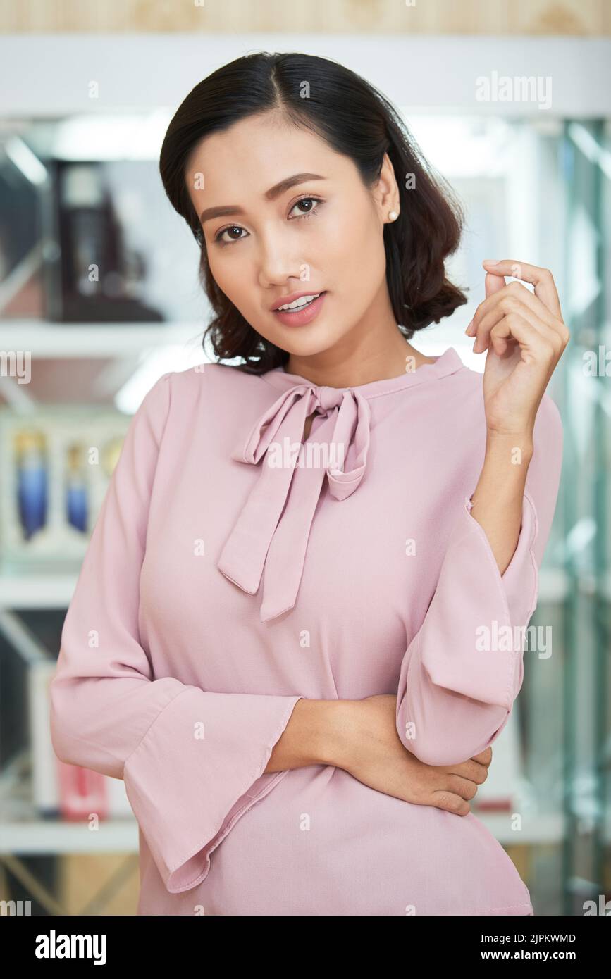 Waist-up portrait of beautiful young woman posing for photography while ...