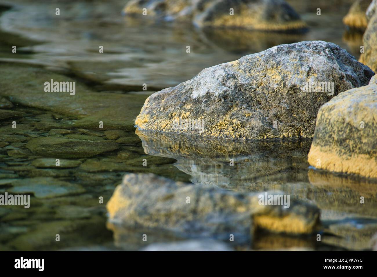 A clear water with the reflection of the rocks Stock Photo - Alamy