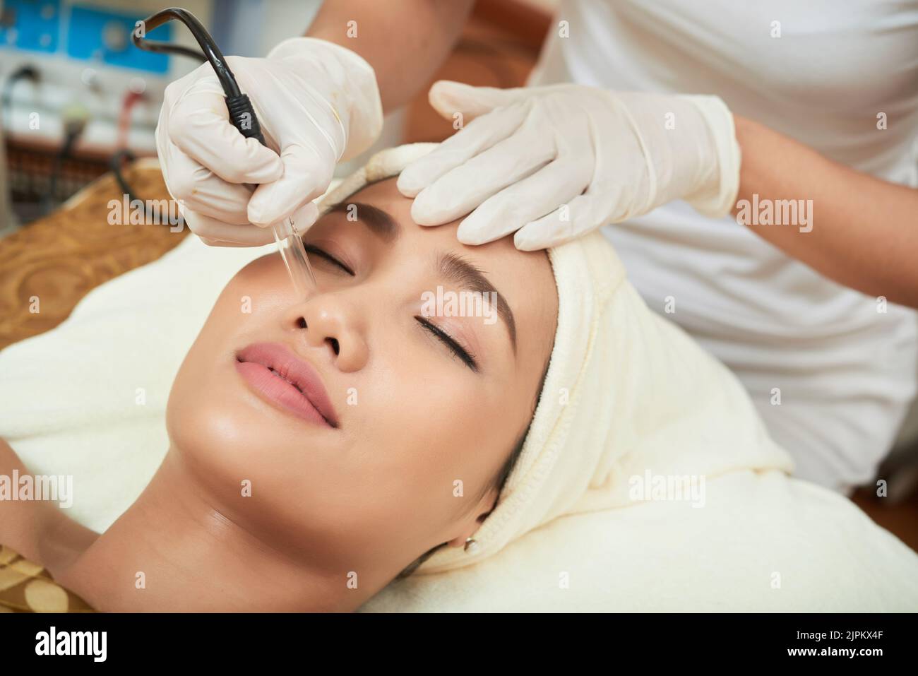 Headshot of pretty Asian woman taking rest on treatment table while ...
