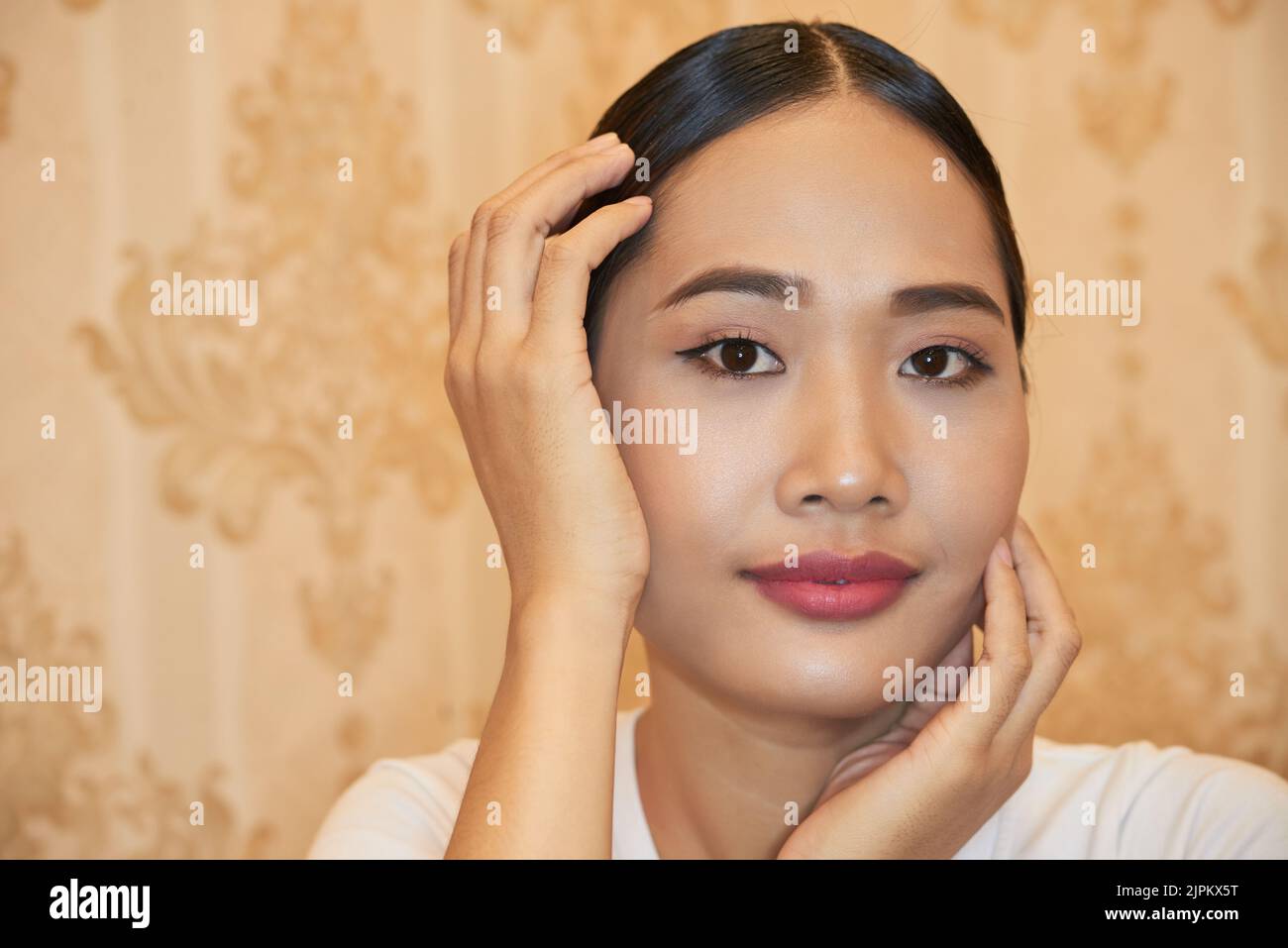 Head and shoulders portrait of beautiful Asian woman looking at camera ...