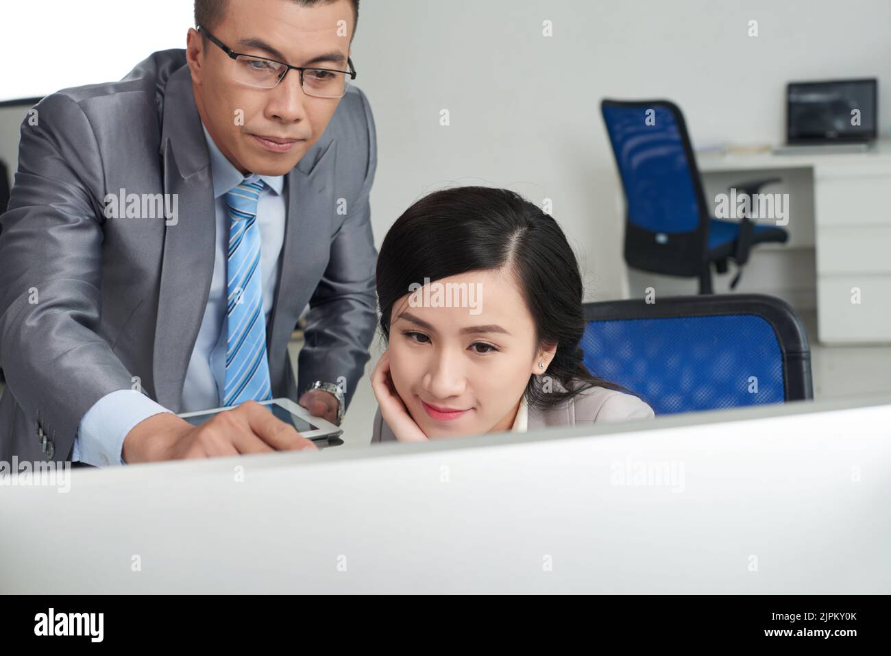 Vietnamese coworkers discussing information on computer screen Stock ...