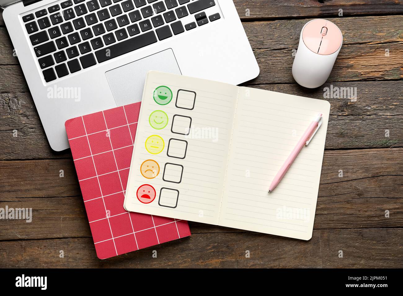 Notebooks with satisfaction rating, pen and laptop on wooden background ...