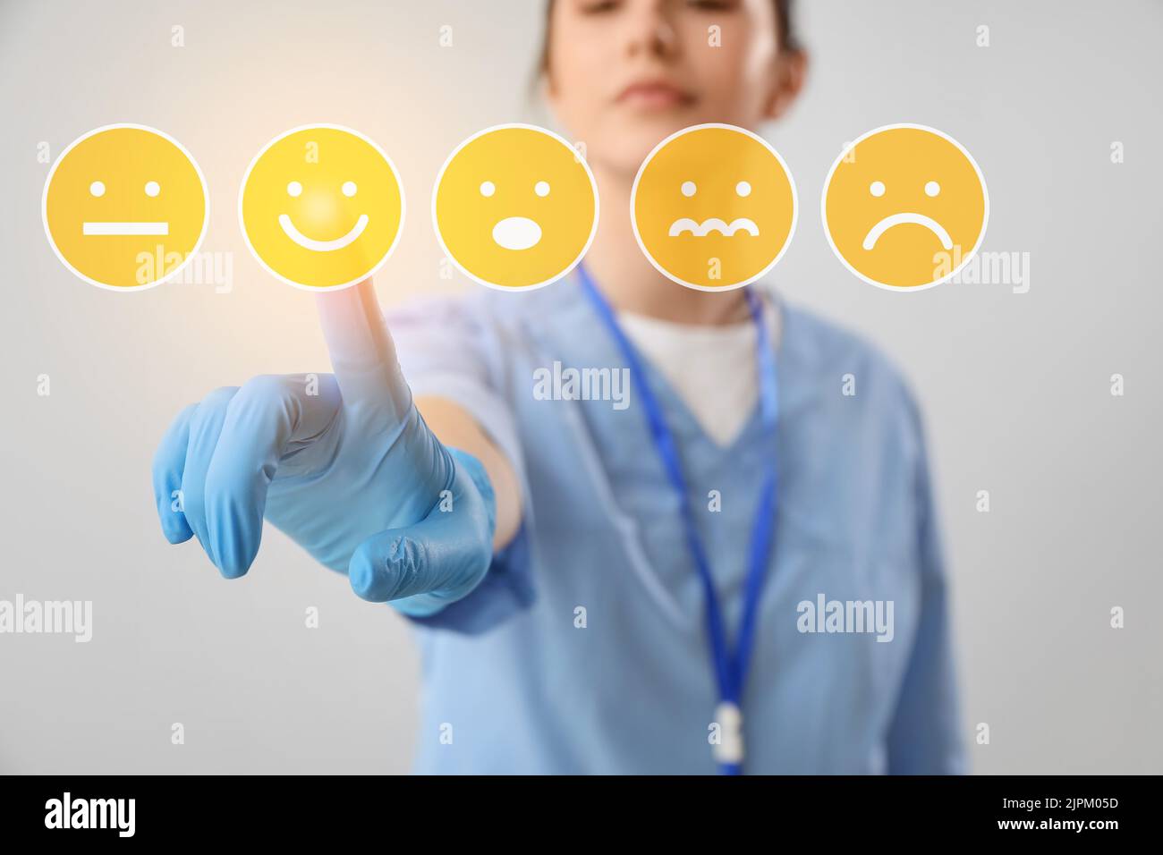 Female doctor pointing at smiling emoticon on virtual screen, closeup ...