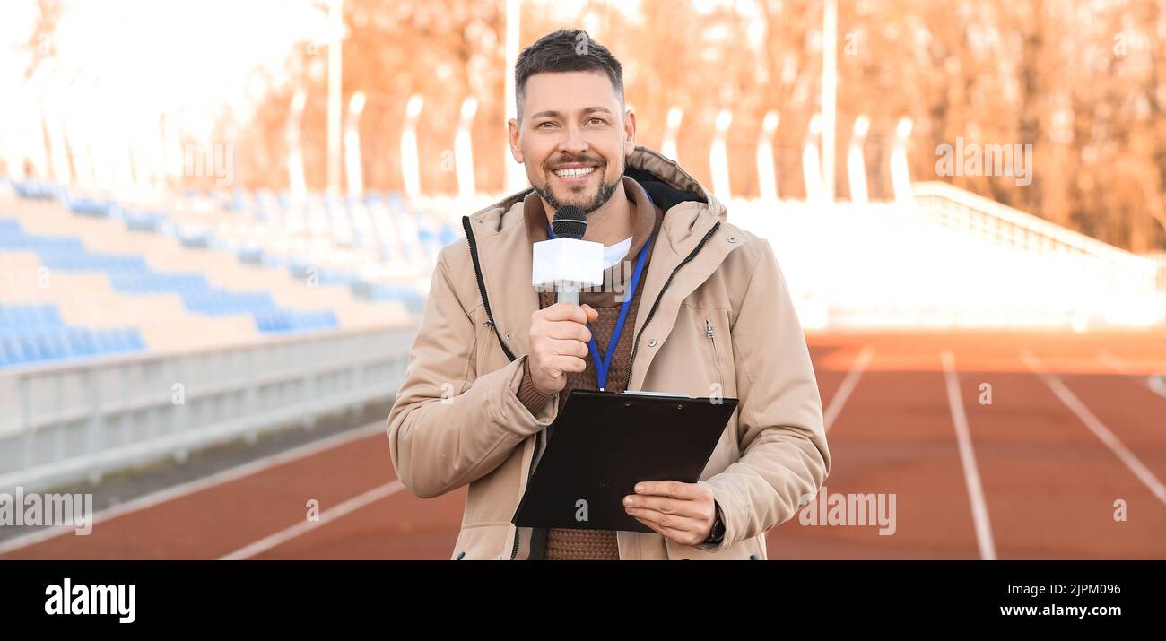 Male reporter with microphone at the stadium Stock Photo - Alamy