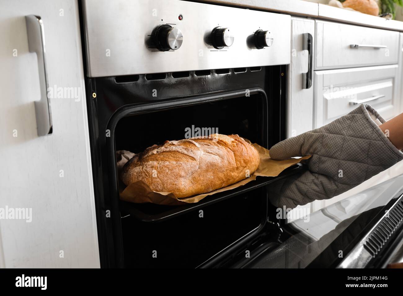 Woman taking baking sheet hi-res stock photography and images - Alamy