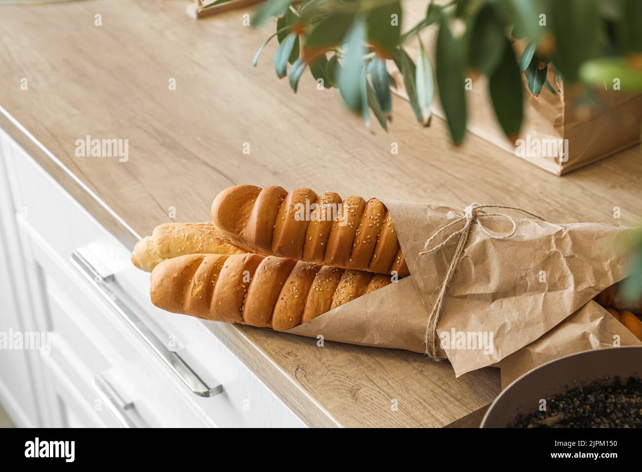 Paper with fresh loaves of bread on kitchen counter, closeup Stock ...