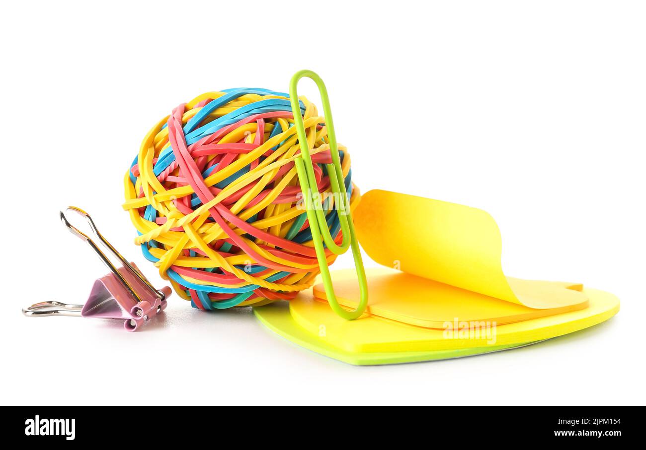 Colorful rubber band ball with paper clips and sticky notes on white ...