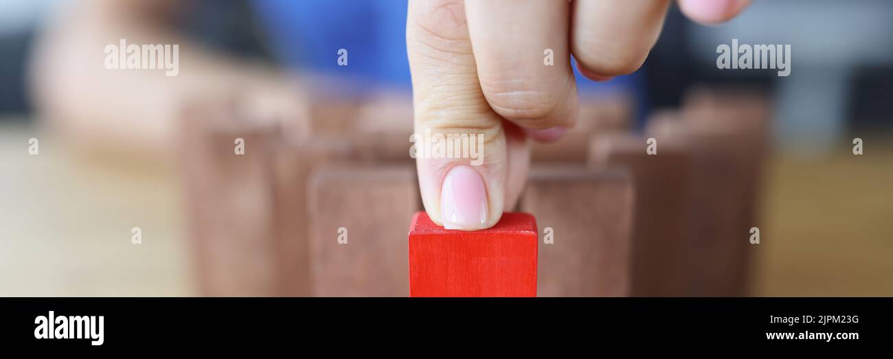 One different red cube block among wooden blocks closeup Stock Photo ...
