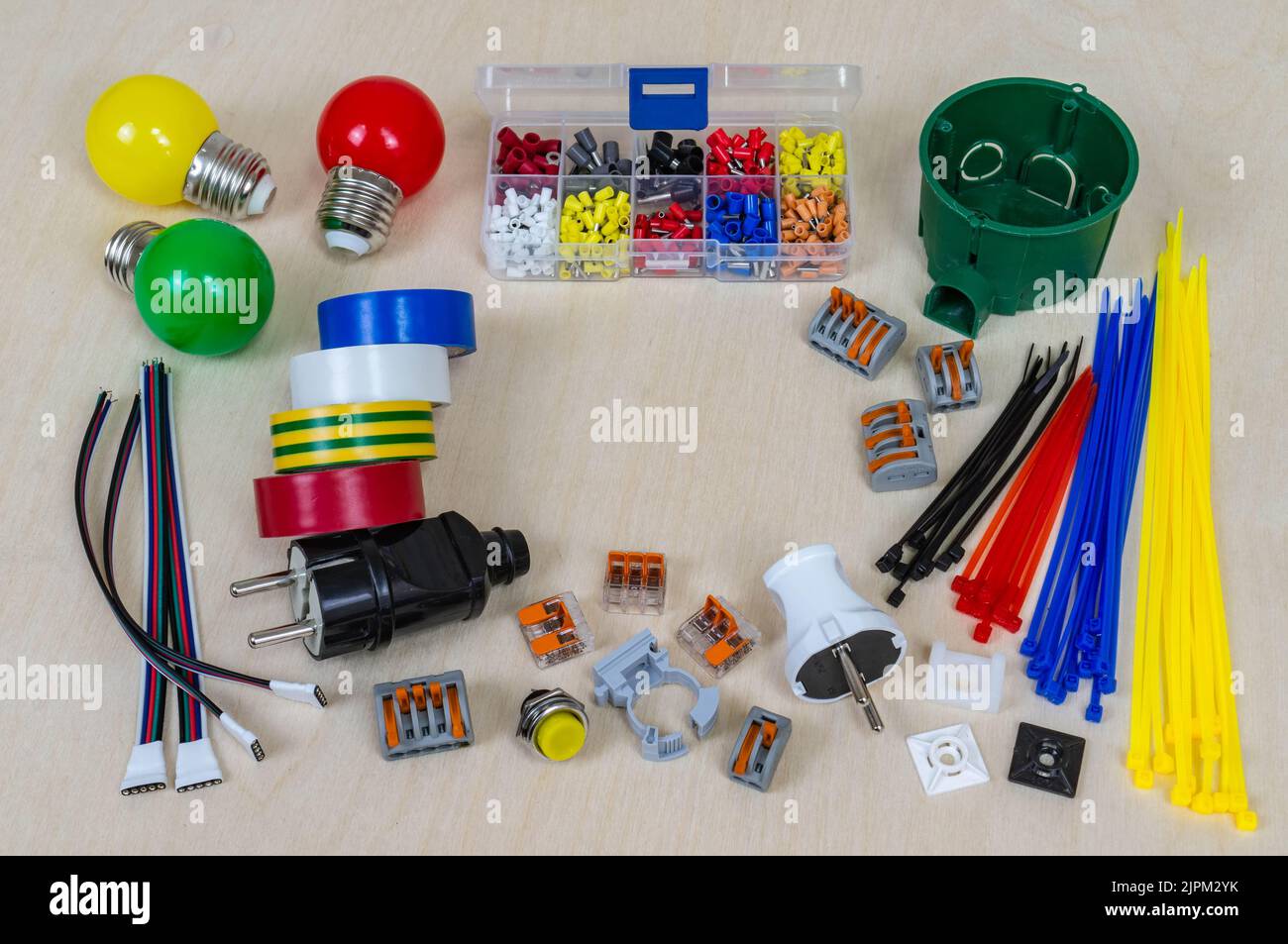 Multi-colored electrical components and parts on a plywood background ...