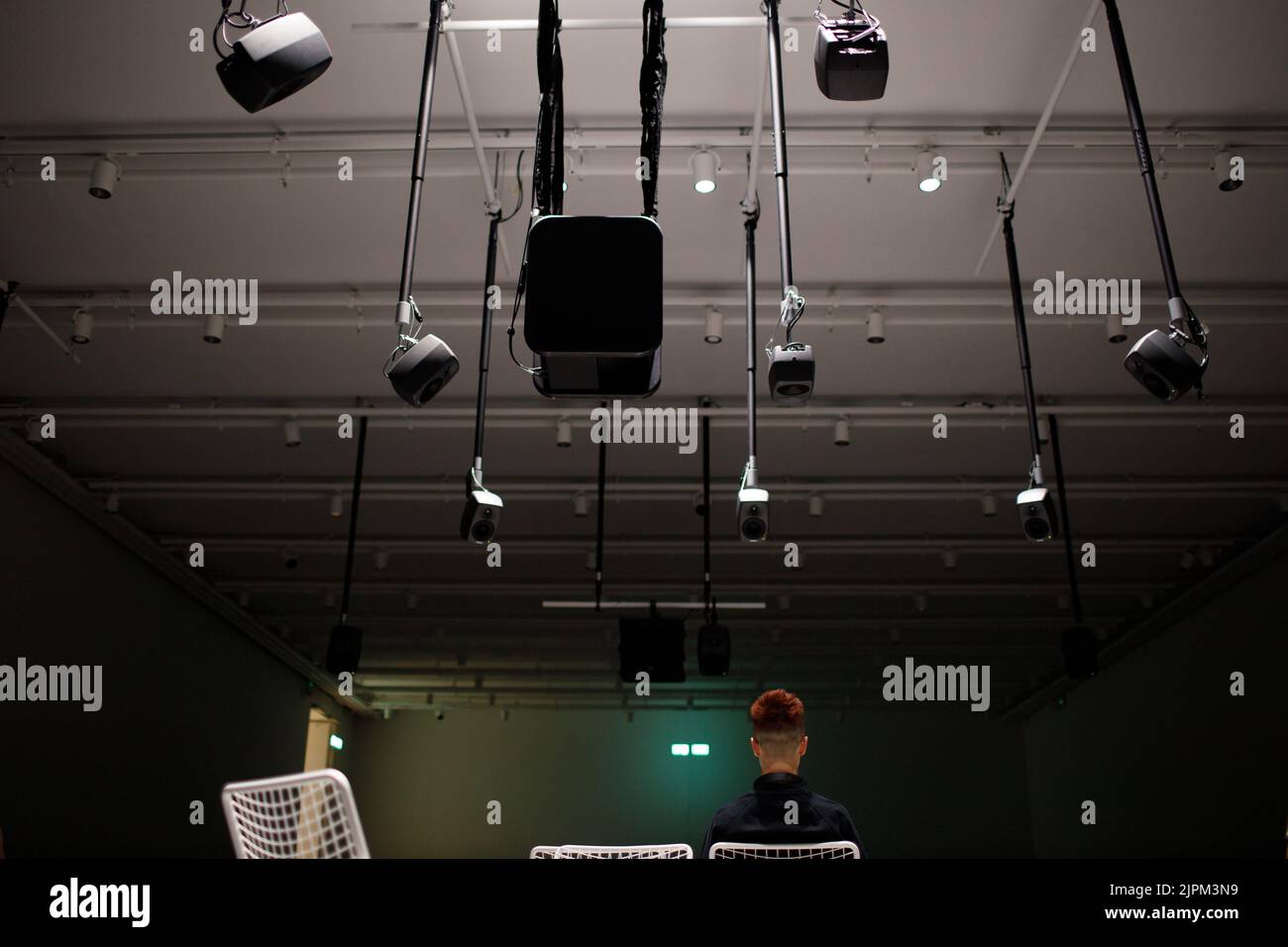 Young man listening to sound music surround installation with many ...