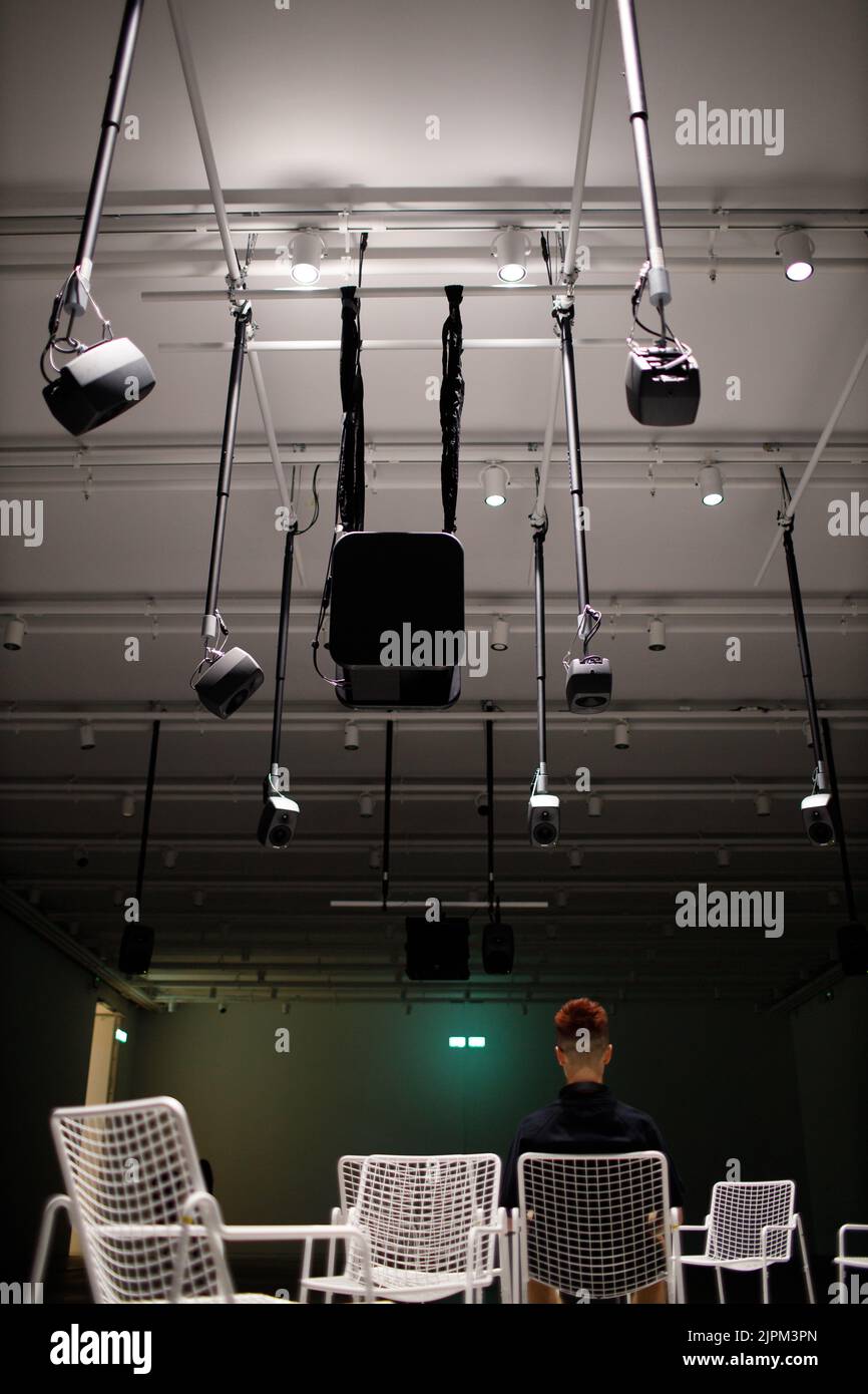 Young man listening to sound music surround installation with many ...
