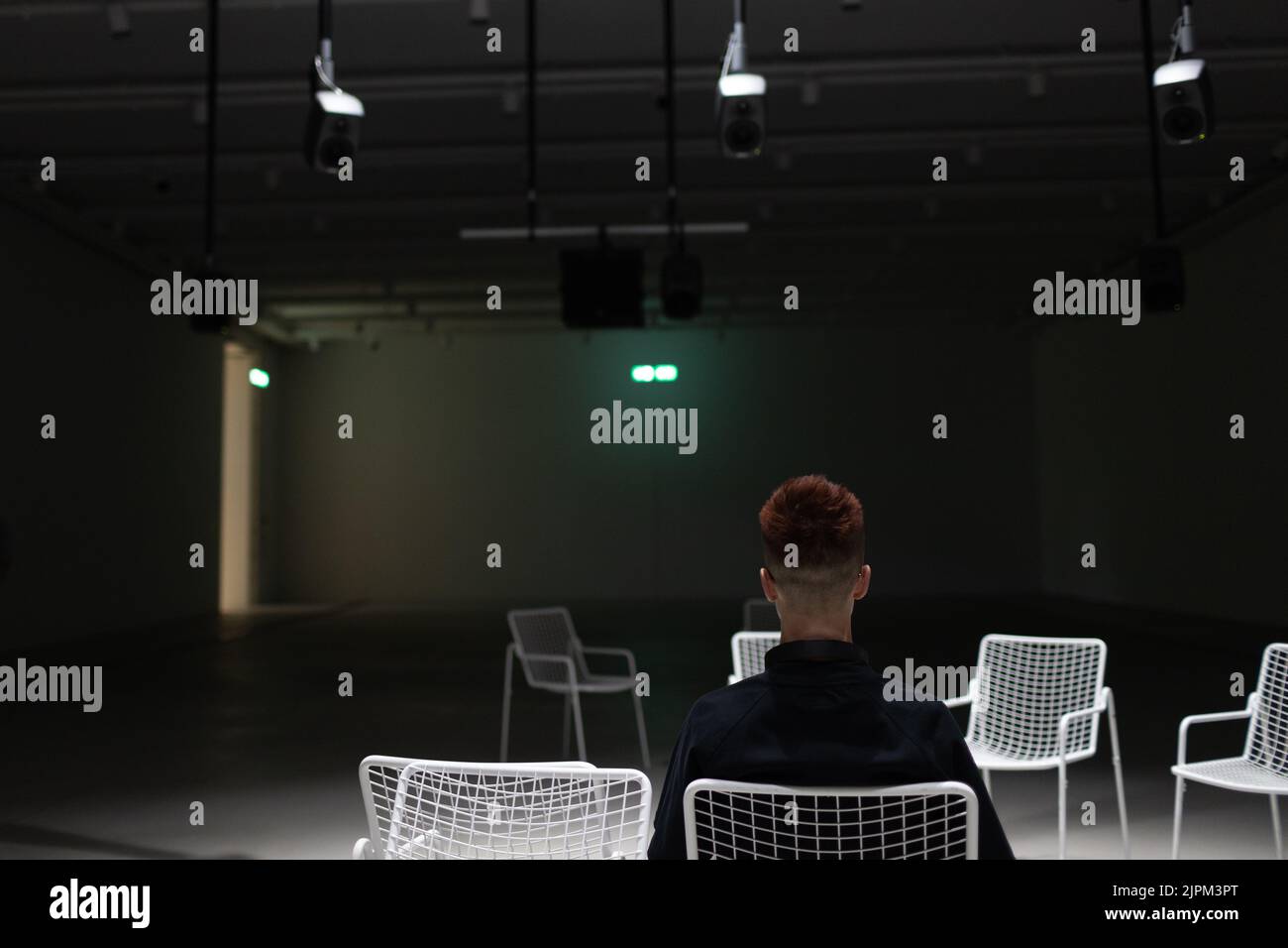 Young man listening to sound music surround installation with many ...