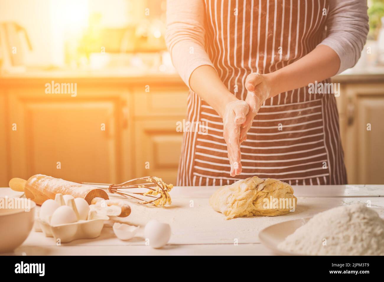 Woman slap his hands above dough closeup. Baker finishing his bakery ...