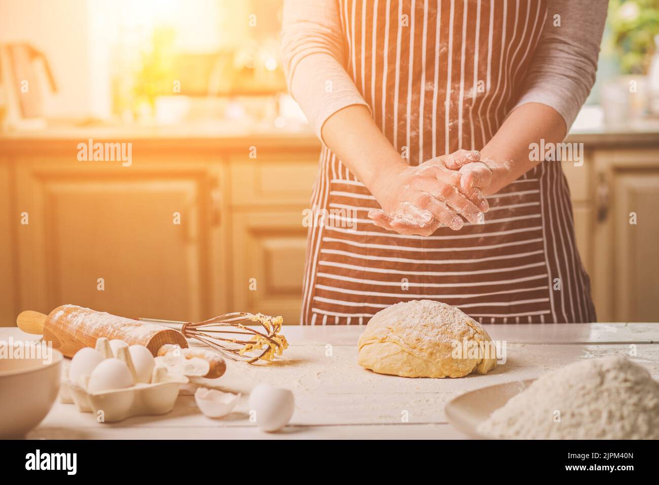 Woman slap his hands above dough closeup. Baker finishing his bakery ...