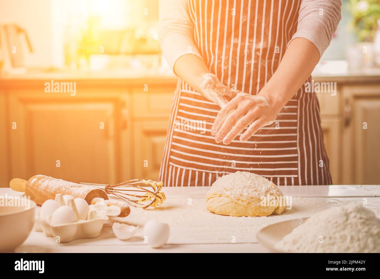 Woman slap his hands above dough closeup. Baker finishing his bakery ...
