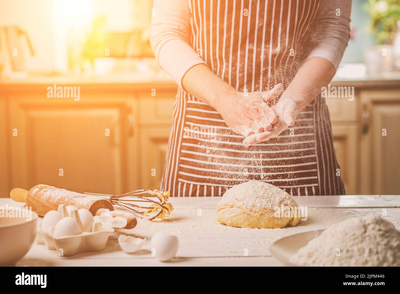 Woman slap his hands above dough closeup. Baker finishing his bakery ...
