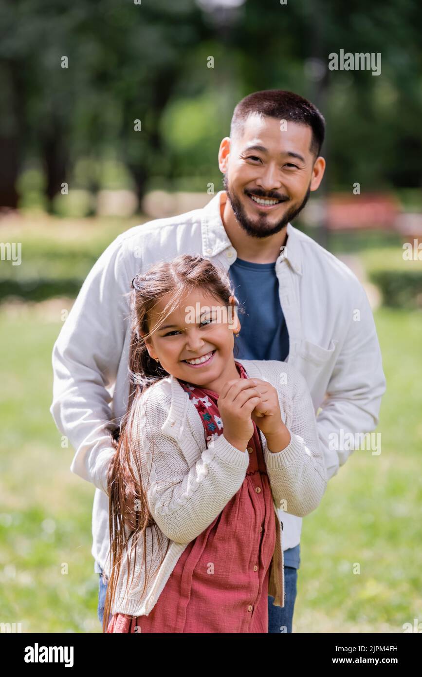 Happy asian father and daughter looking at camera in park Stock Photo ...