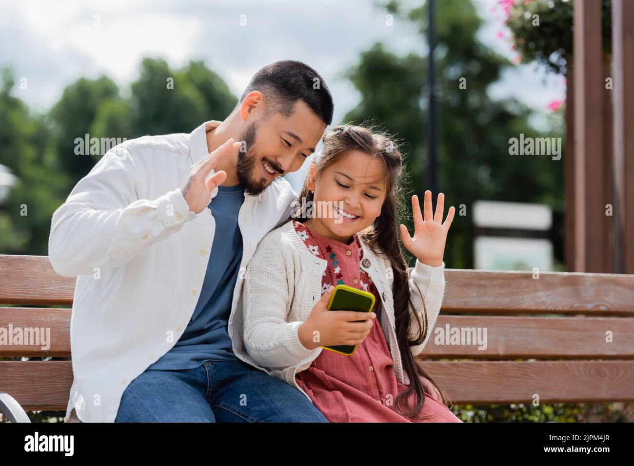 Positive asian father and daughter having video call on smartphone on ...