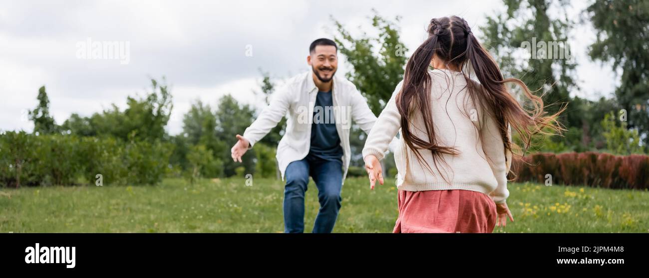 Preteen kid running to asian father in summer park, banner Stock Photo ...
