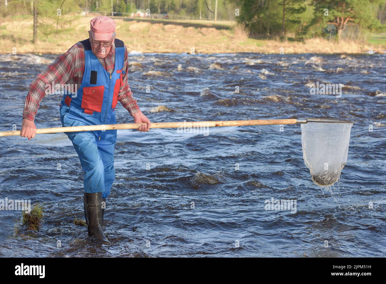 A view of an adult Caucasian man fishing for smelt in Viannankoski ...