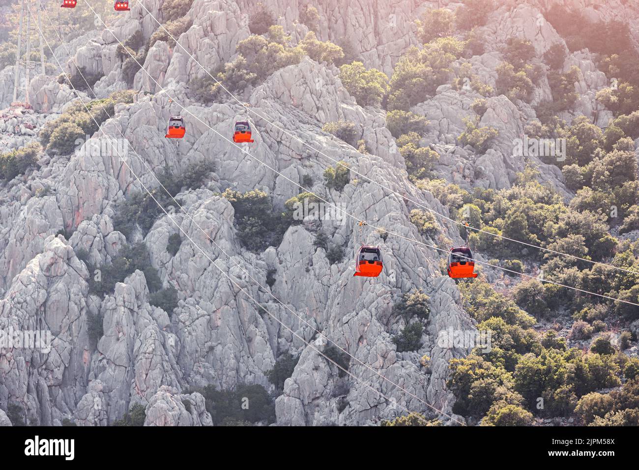 Cable car carries tourists in closed gondolas to a viewing platform ...