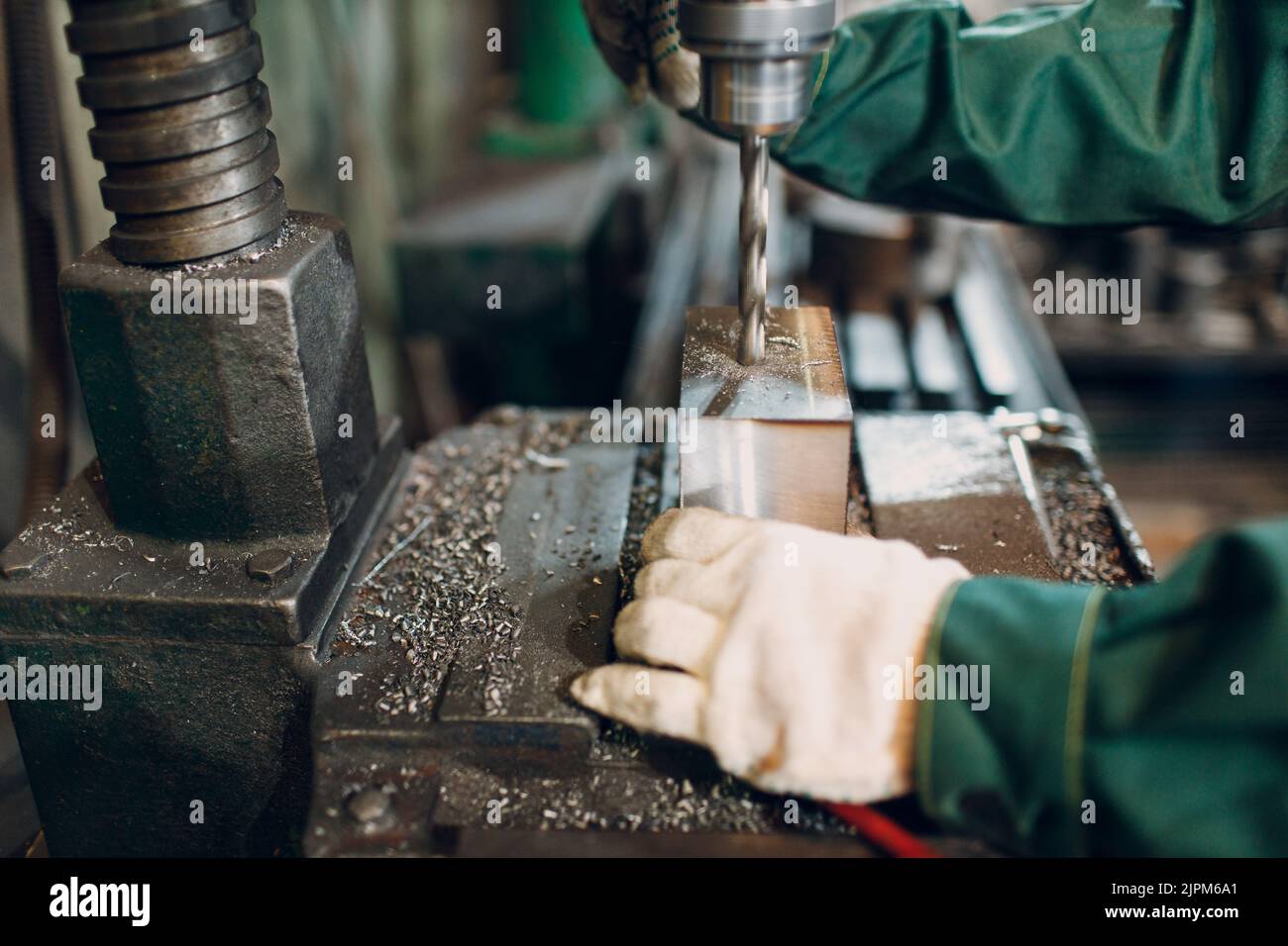 Worker with drilling boring machine works on metal factory Stock Photo ...