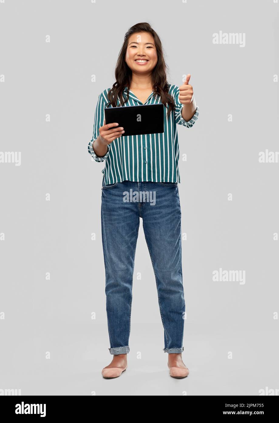 happy asian woman with tablet pc showing thumbs up Stock Photo - Alamy