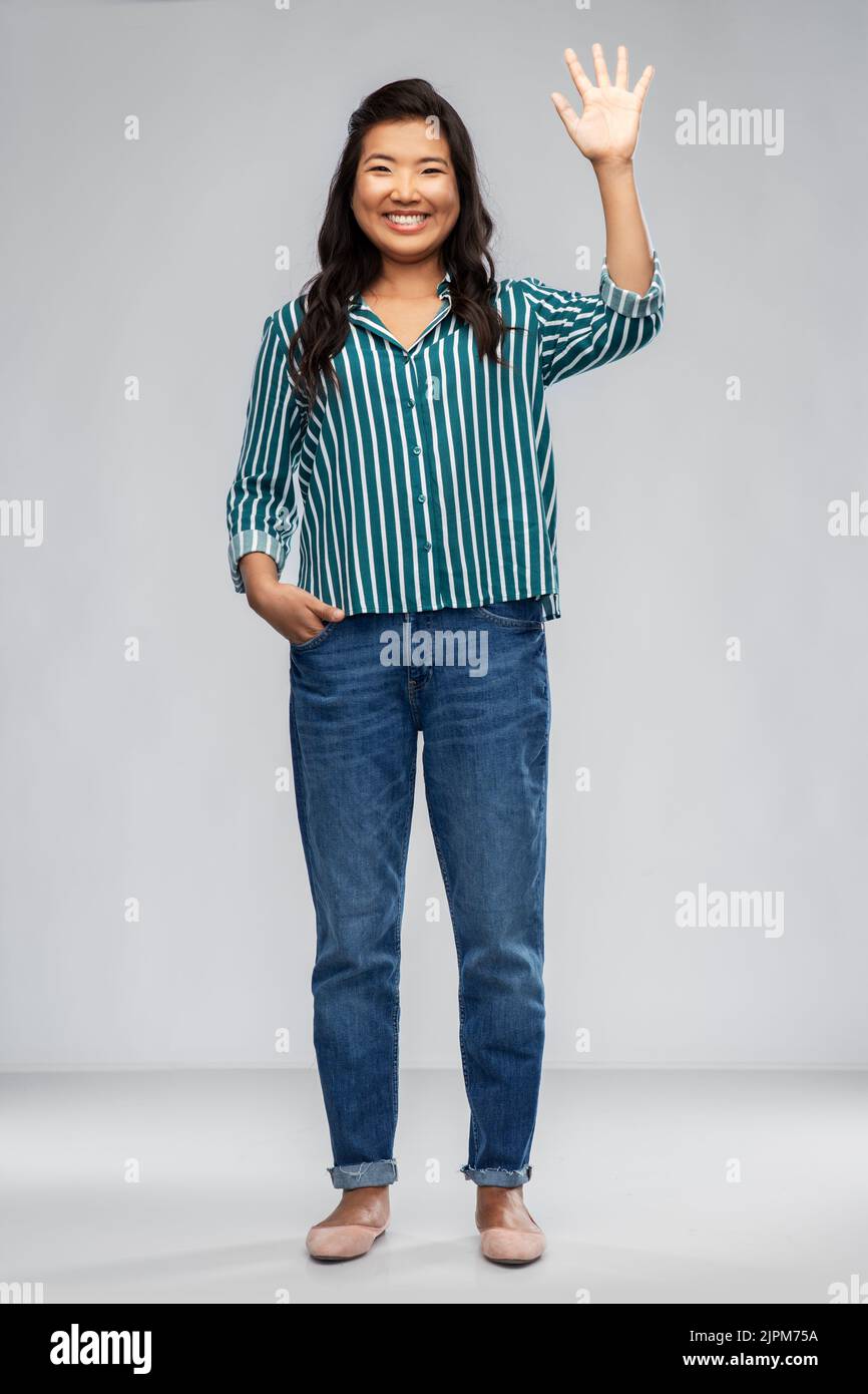 happy smiling asian woman waving hand Stock Photo - Alamy
