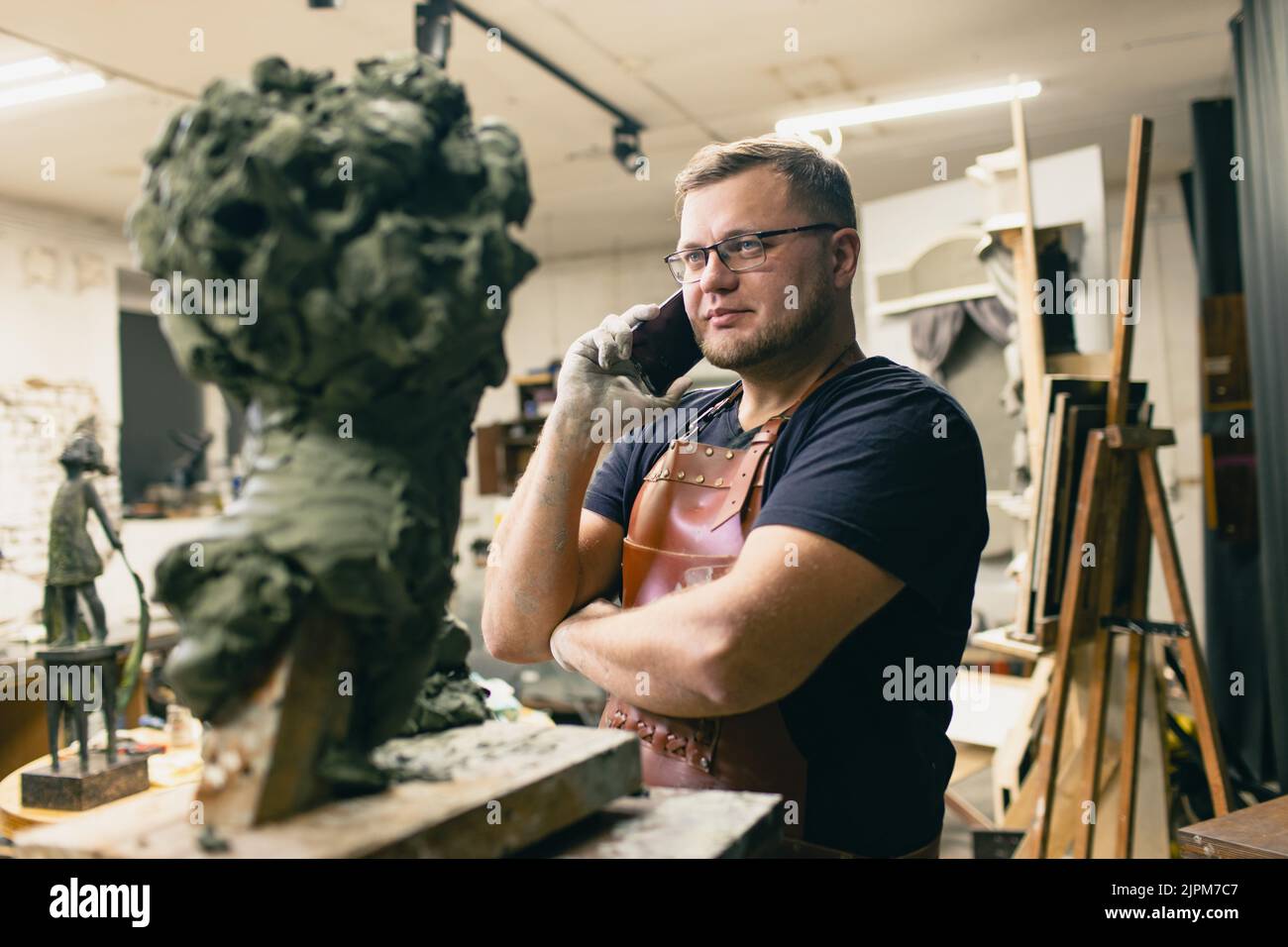 Man sculptor creates sculpt bust clay human woman sculpture and calling ...