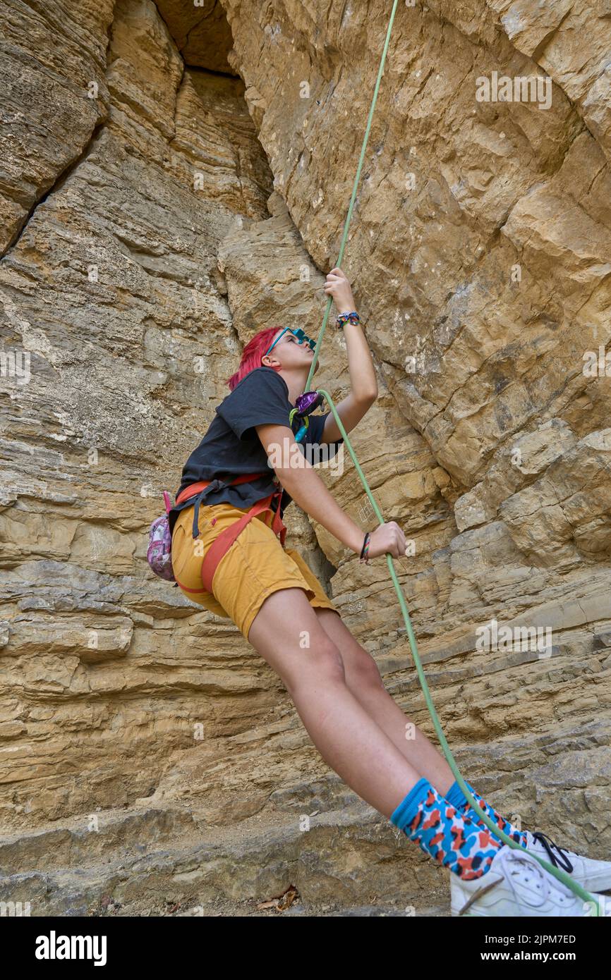 Teenage girl securing her climbing partner by a securing rope system ...