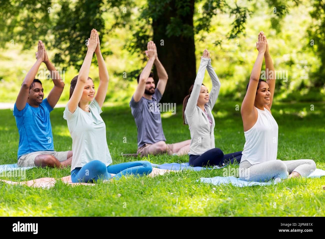group of happy people doing yoga at summer park Stock Photo - Alamy