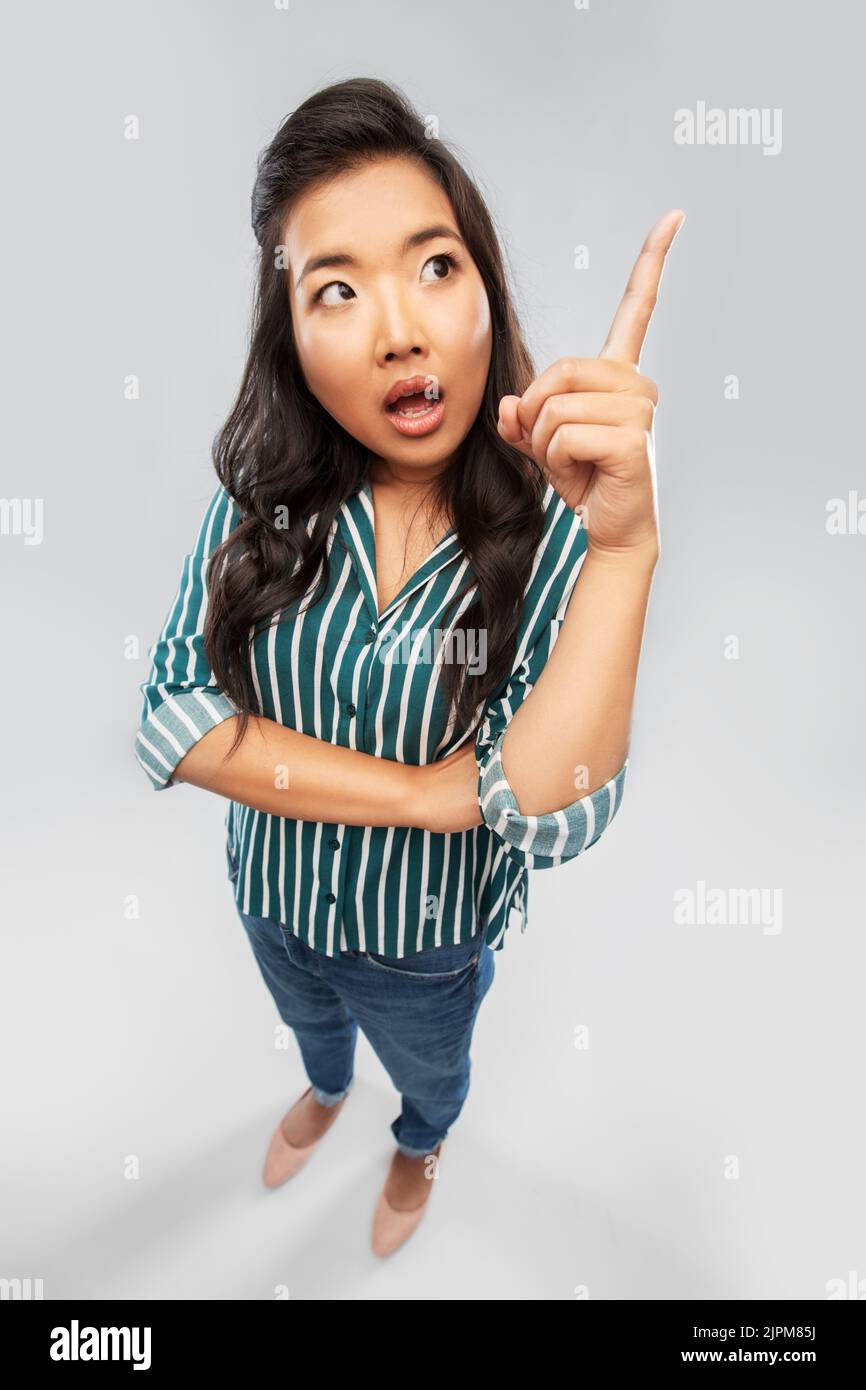 asian woman pointing finger up Stock Photo - Alamy