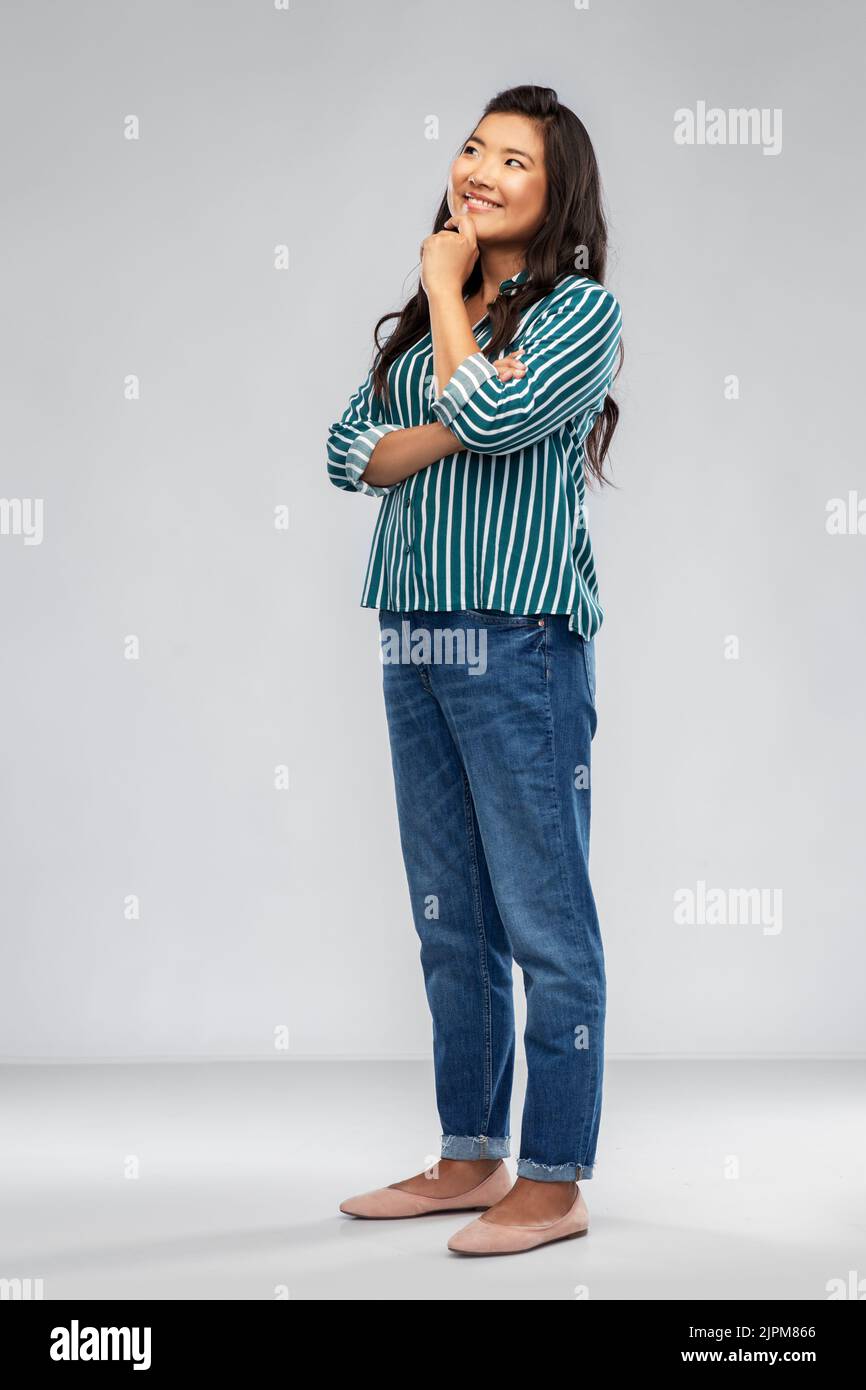 happy smiling asian woman looking up and thinking Stock Photo - Alamy