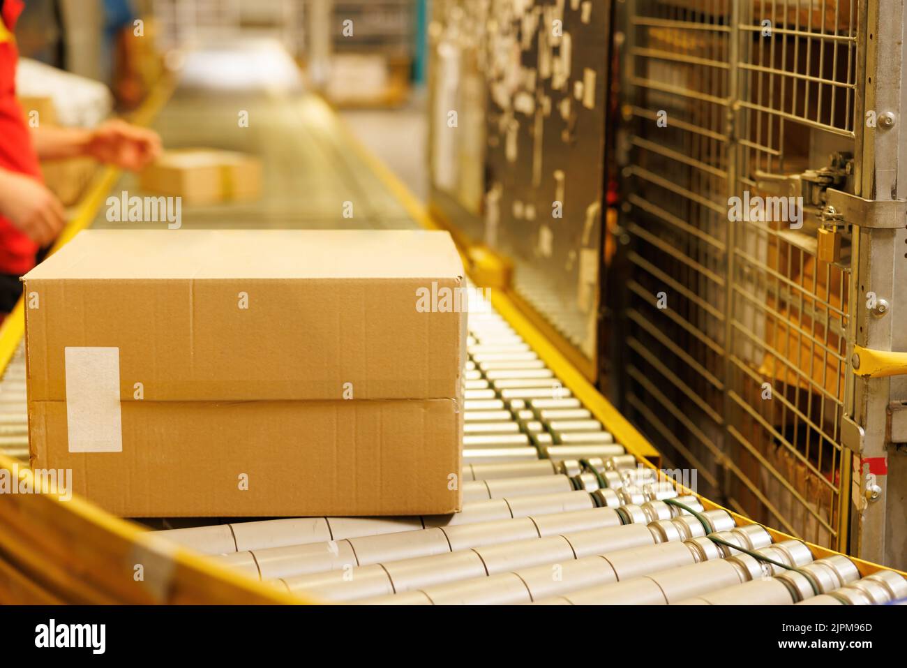 Boxes on conveyor belt in a big warehouse Stock Photo - Alamy