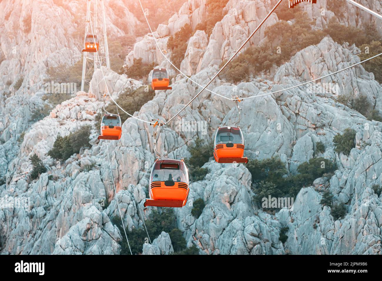Cable car carries tourists in closed gondolas to a viewing platform ...