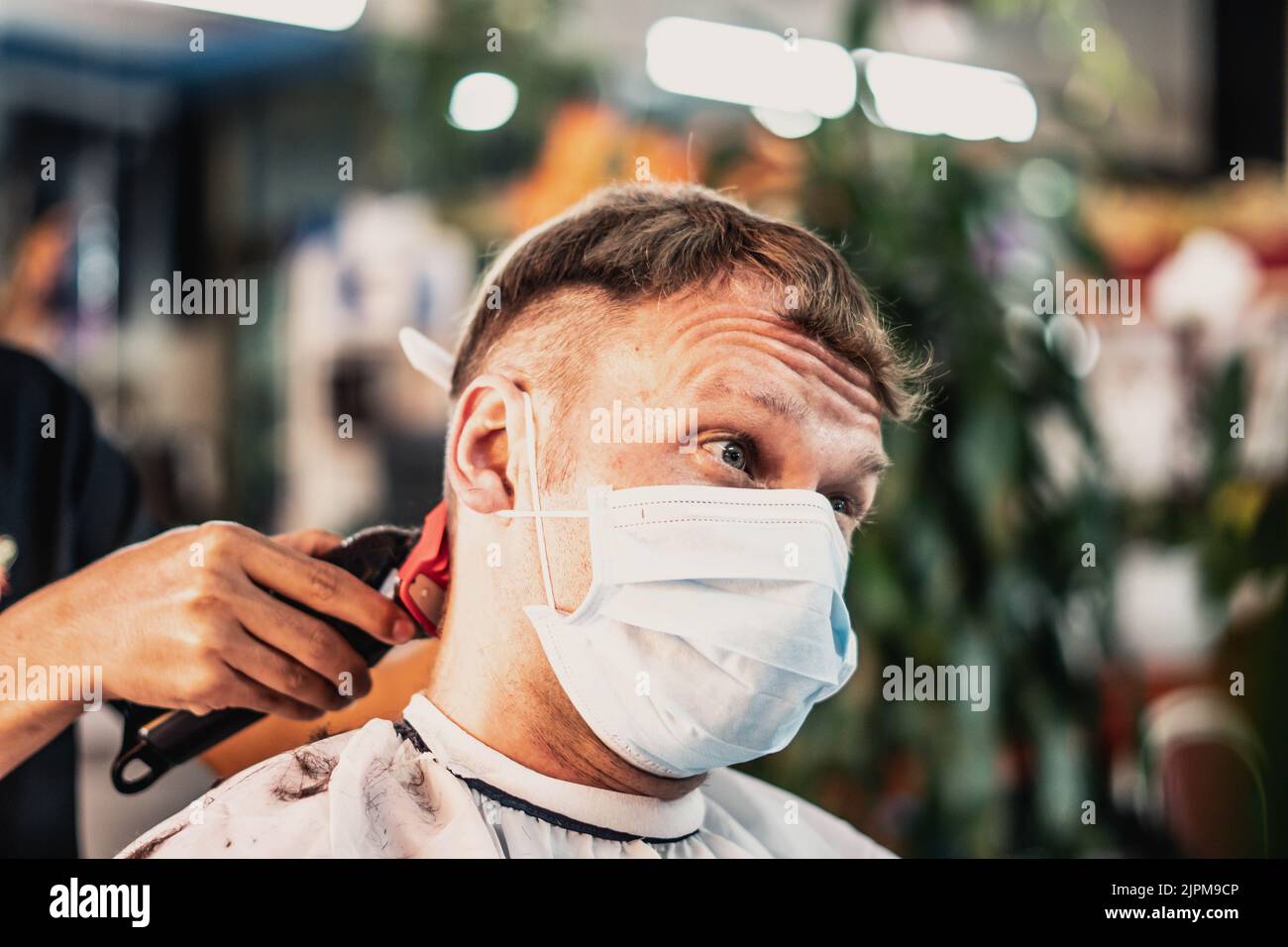 Lifestyle photo barbershop. Young man customer wears face mask ...