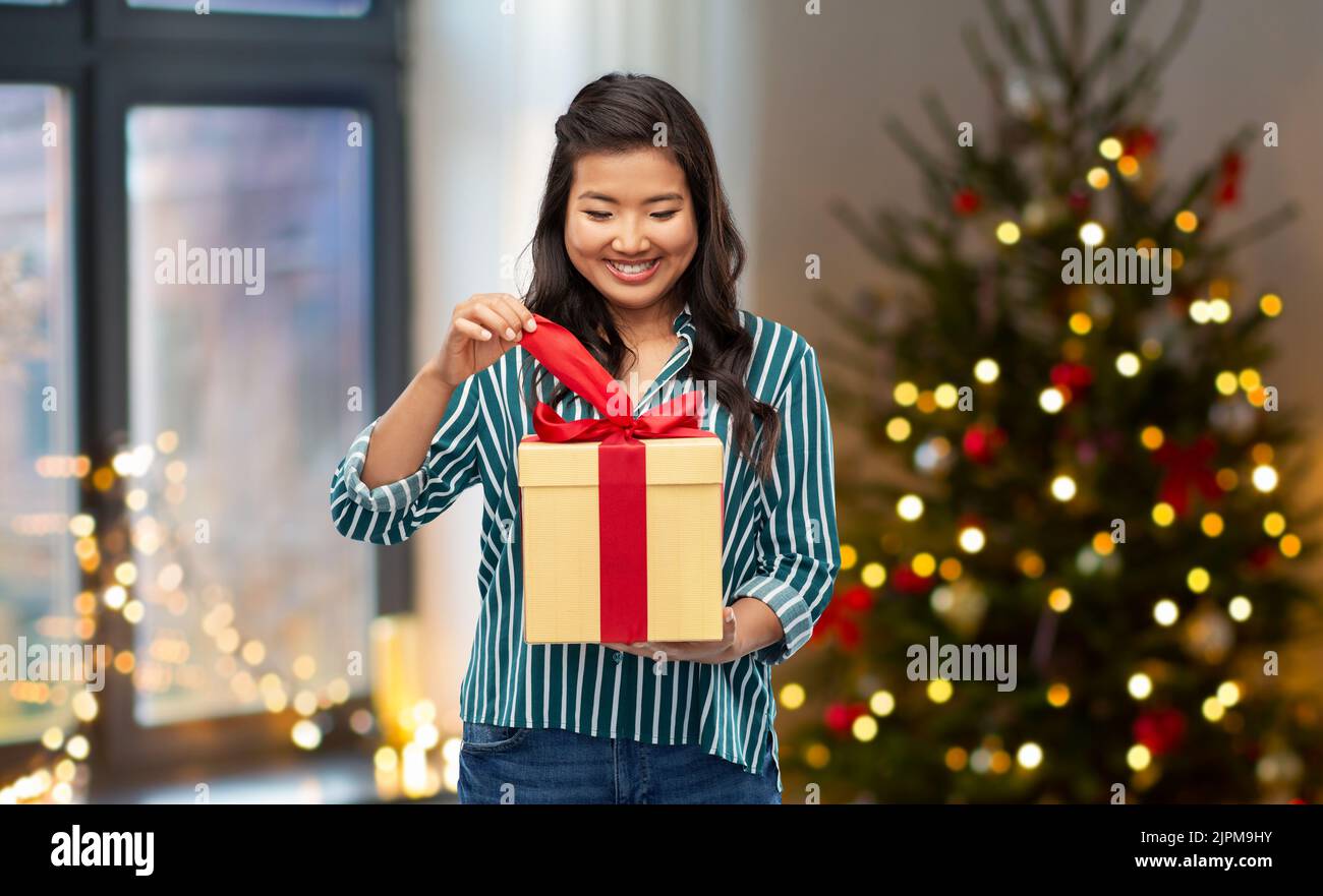 happy asian woman opening christmas gift at home Stock Photo - Alamy